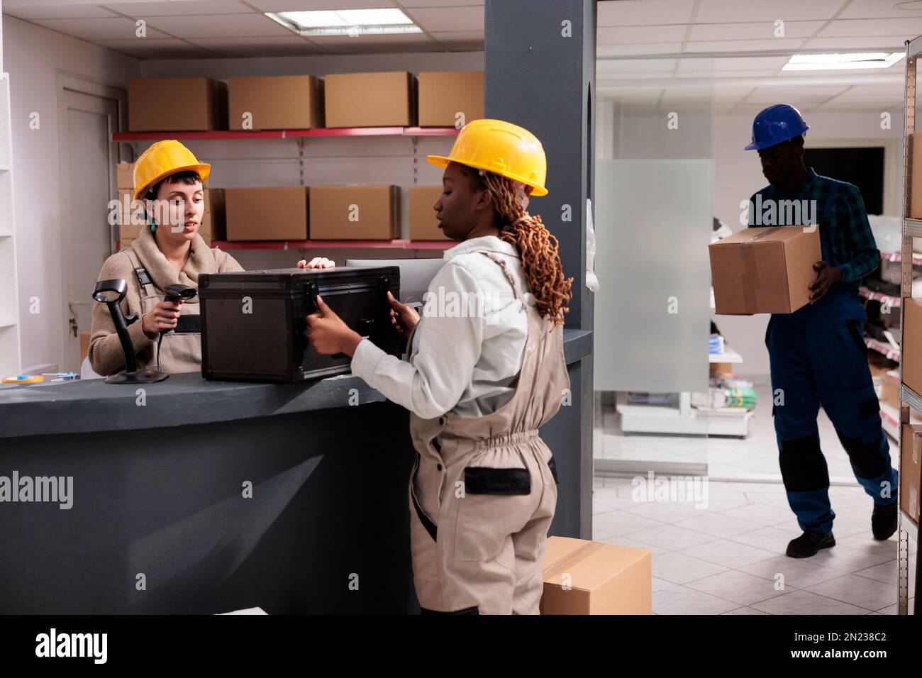 Delivery office warehouse worker scanning suitcase at reception desk ...