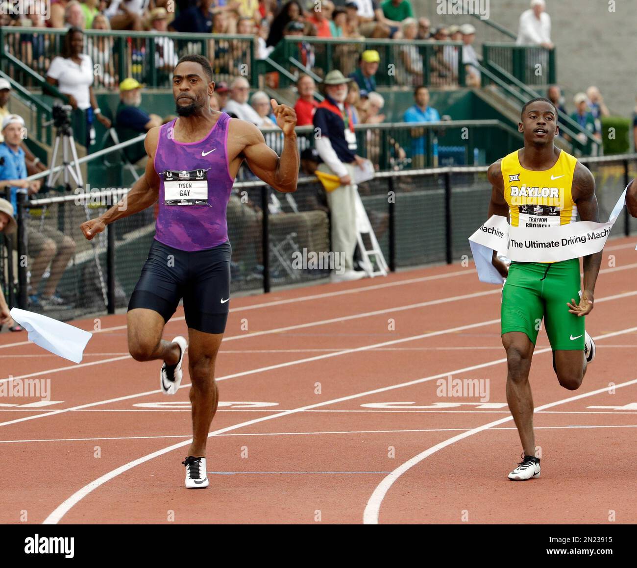 Tyson Gay, left, hits the tape ahead of Trayvon Bromell to win the 100 ...