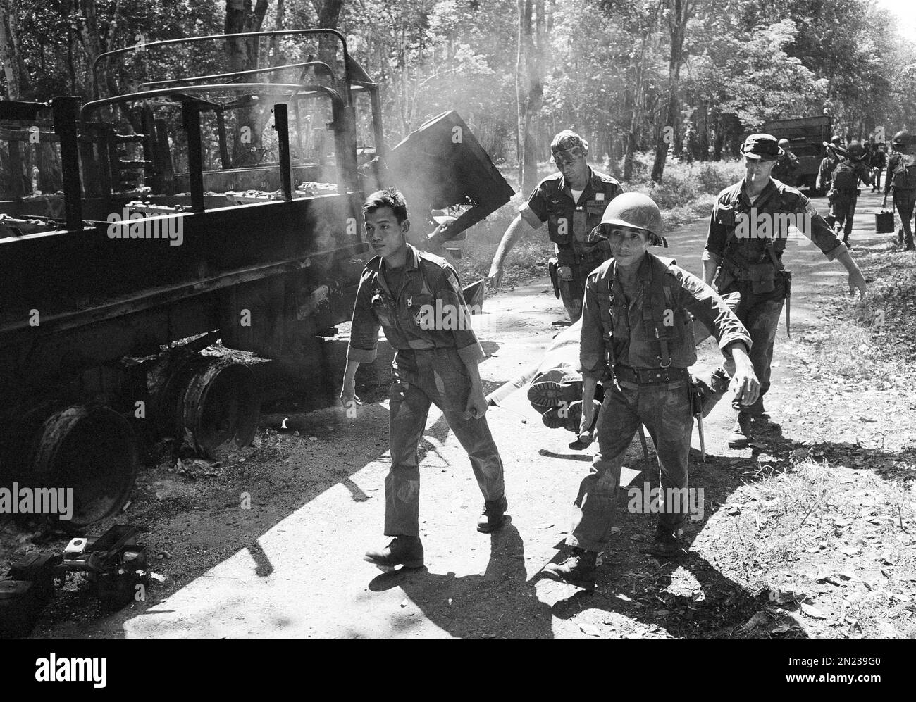 U.S. and South Vietnamese soldiers carry a stretcher with the body of a ...