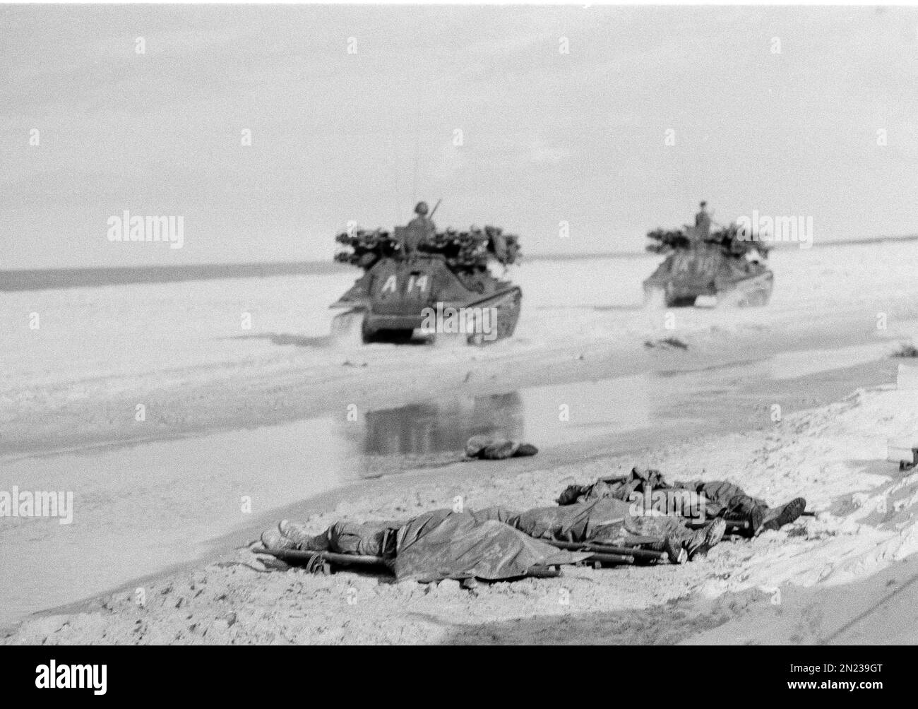 Bodies of three dead Marines, wrapped in ponchos, lie on stretchers ...