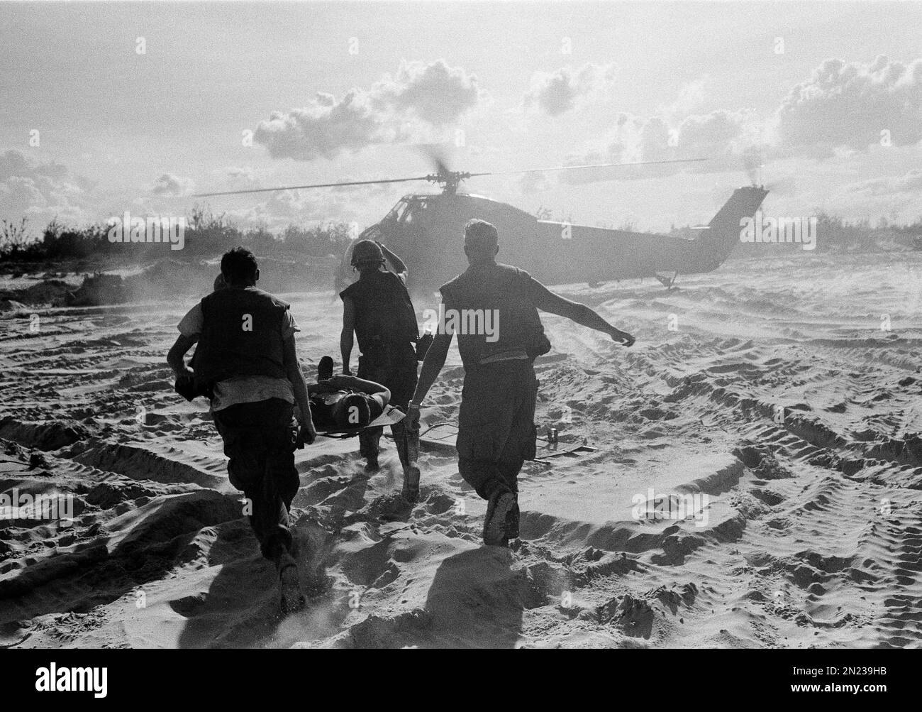 U.S. Marine stretcher bearers rush a seriously wounded leatherneck across the sand to an ...