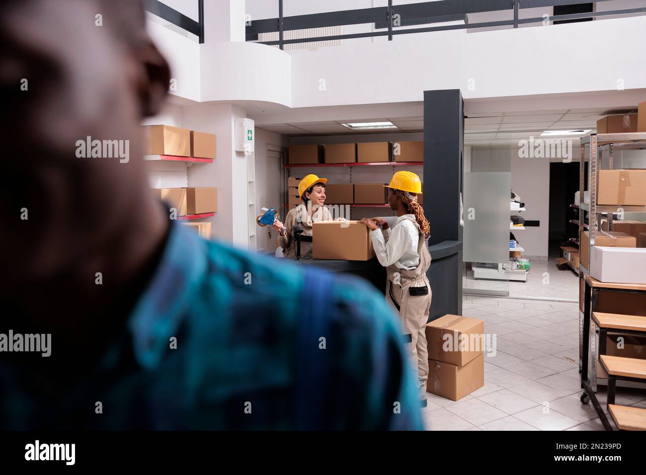 Shipping department managers packing client order with sticky tape ...