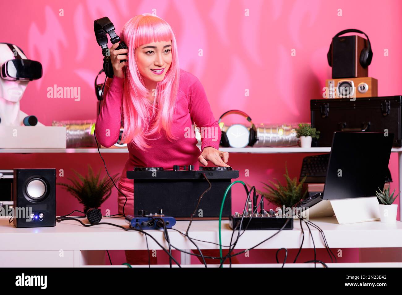 Asian musician standing at dj table enjoying to perform electronic ...
