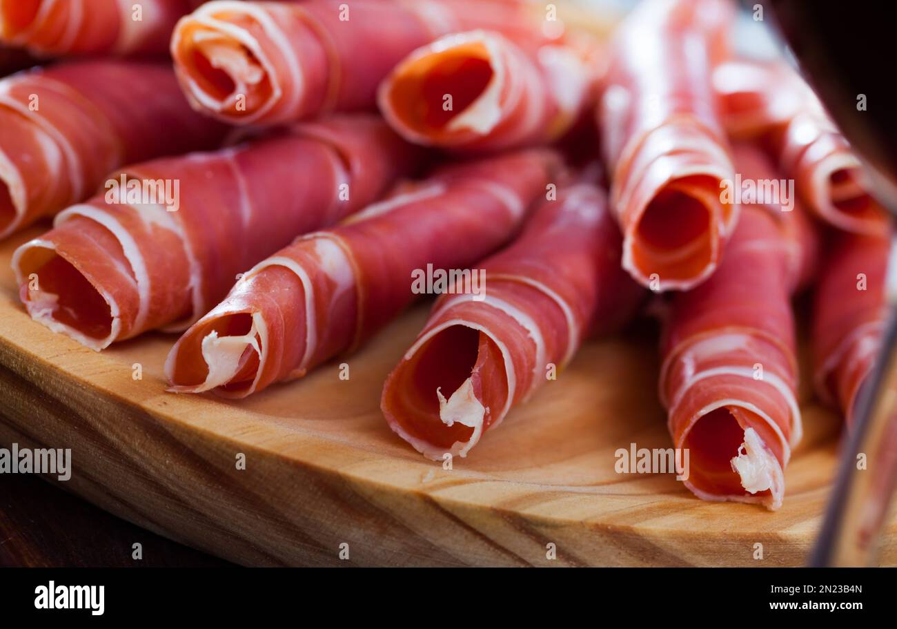 Rolled up slices of dry-cured ham Stock Photo - Alamy