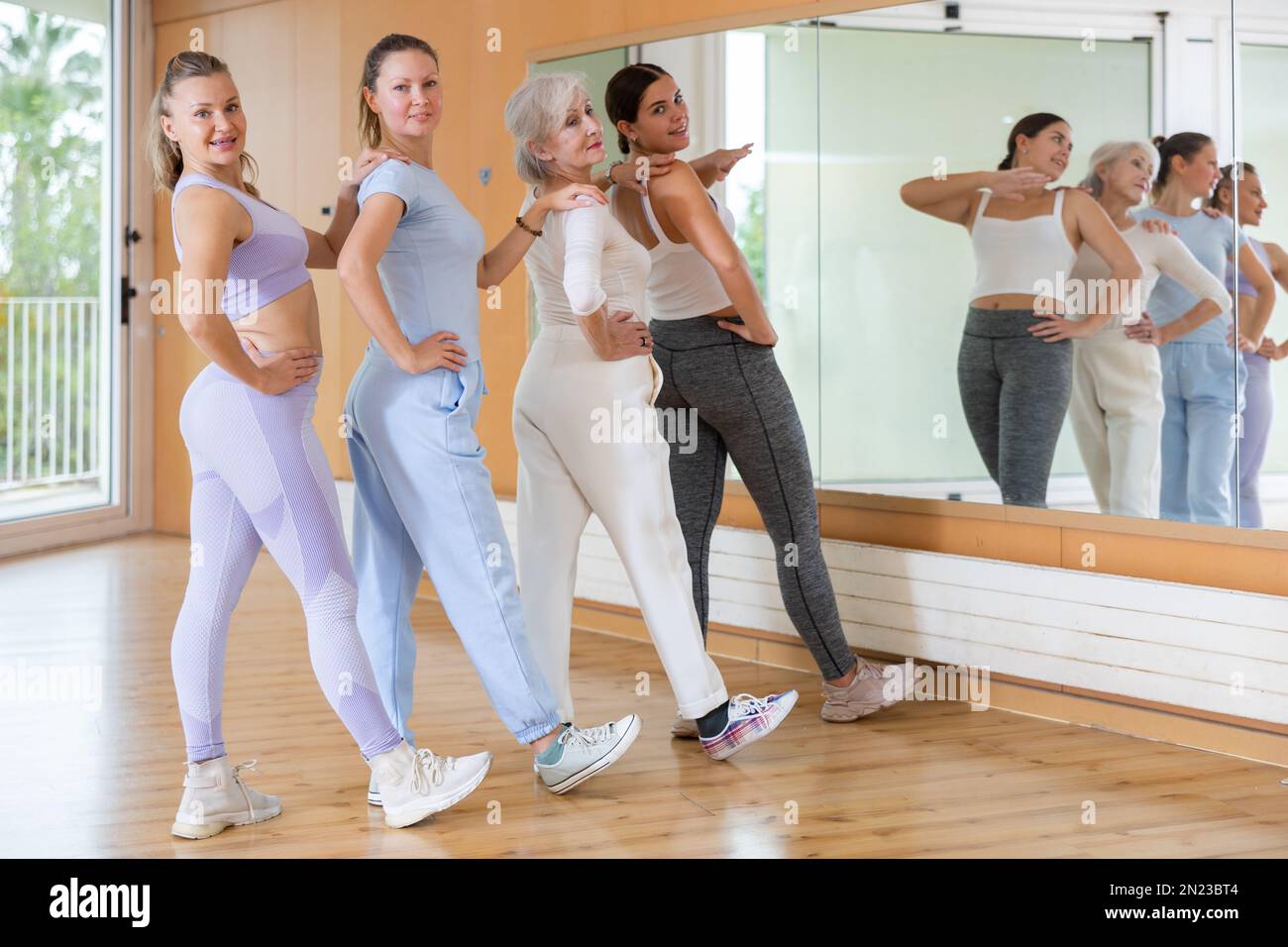 Portrait of four sportive active women of different ages standing in ...