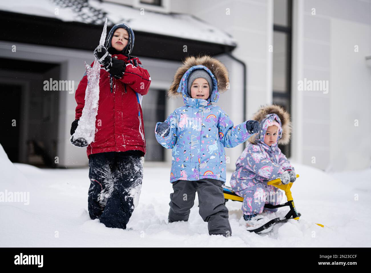 Children play outdoors in snow. Three kids enjoy a sleigh ride. Child ...