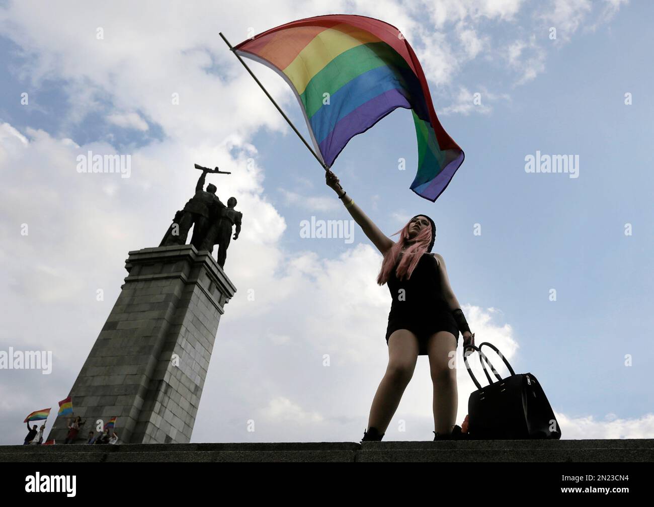 An activist waves a rainbow flag in front of the Monument of the Soviet ...