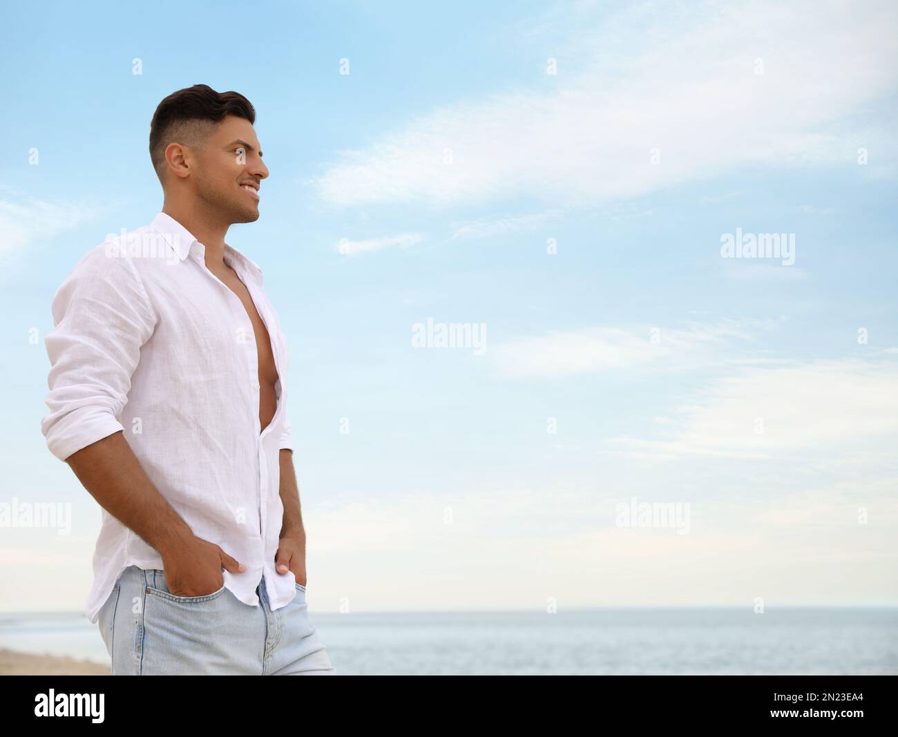 Handsome man on beach near sea. Space for text Stock Photo - Alamy