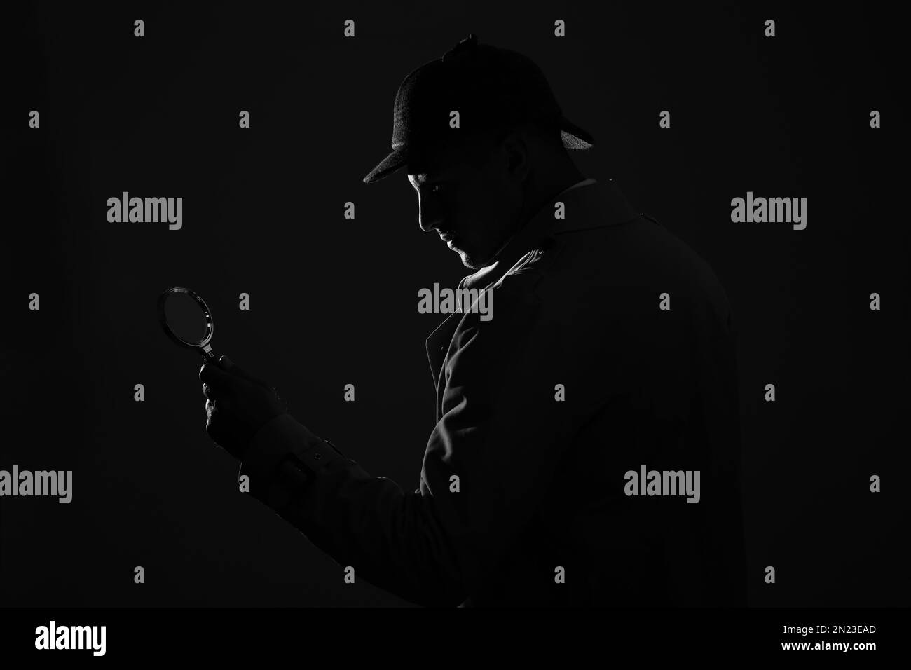 Old fashioned detective with magnifying glass on dark background, black ...