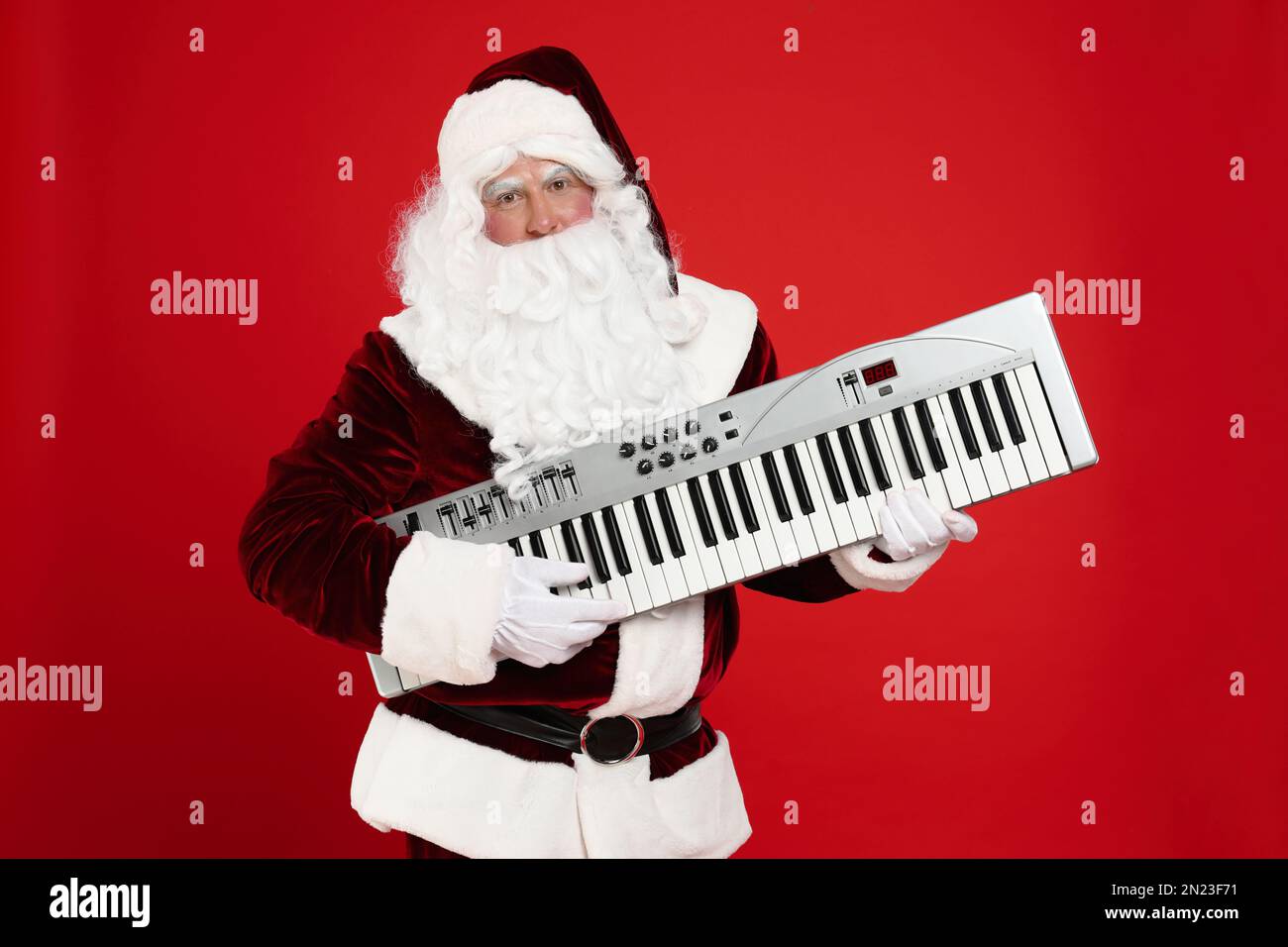 Santa Claus with synthesizer on red background. Christmas music Stock ...