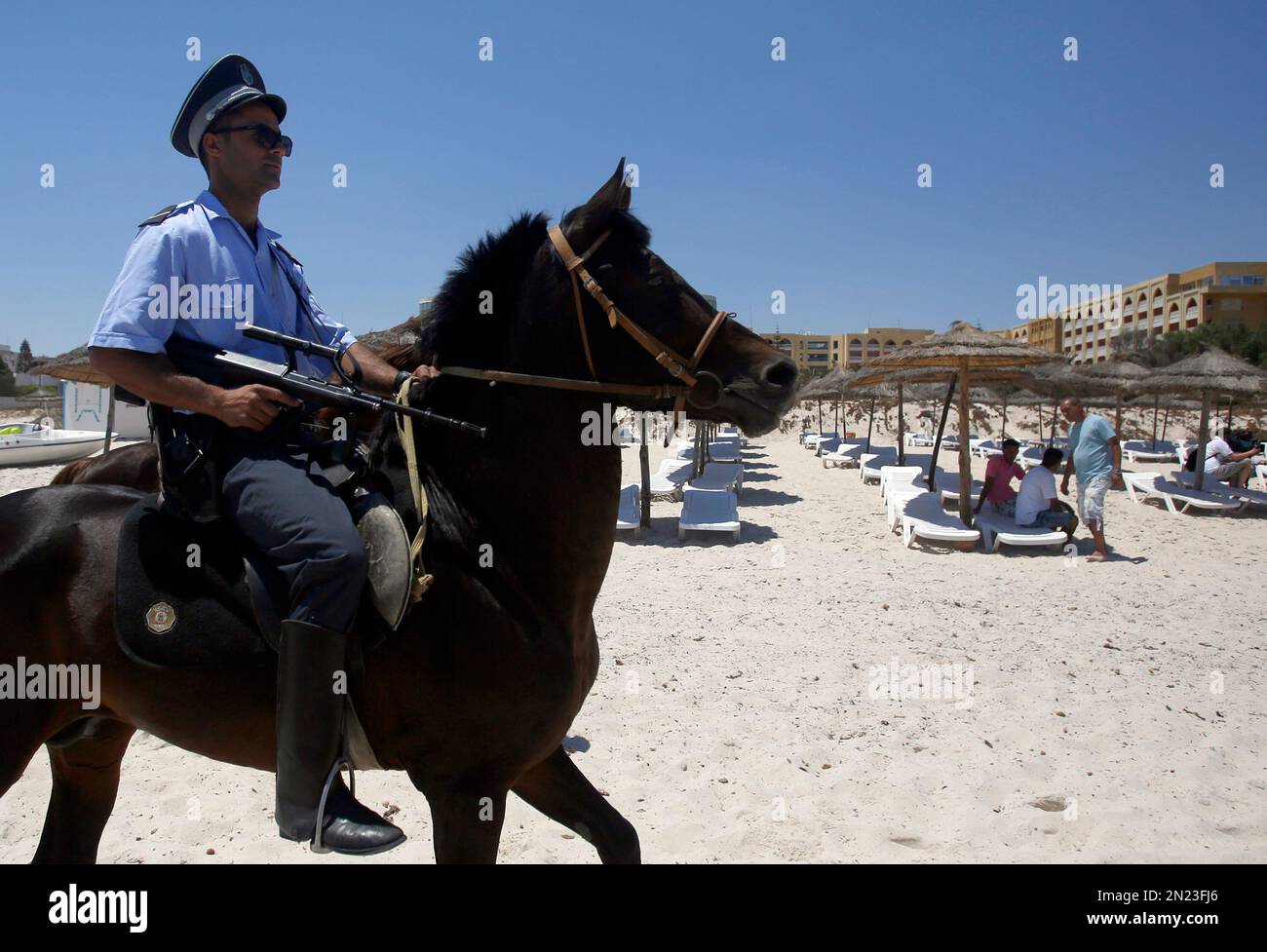 A Tunisian police officer on horse patrol the beach in front of the ...