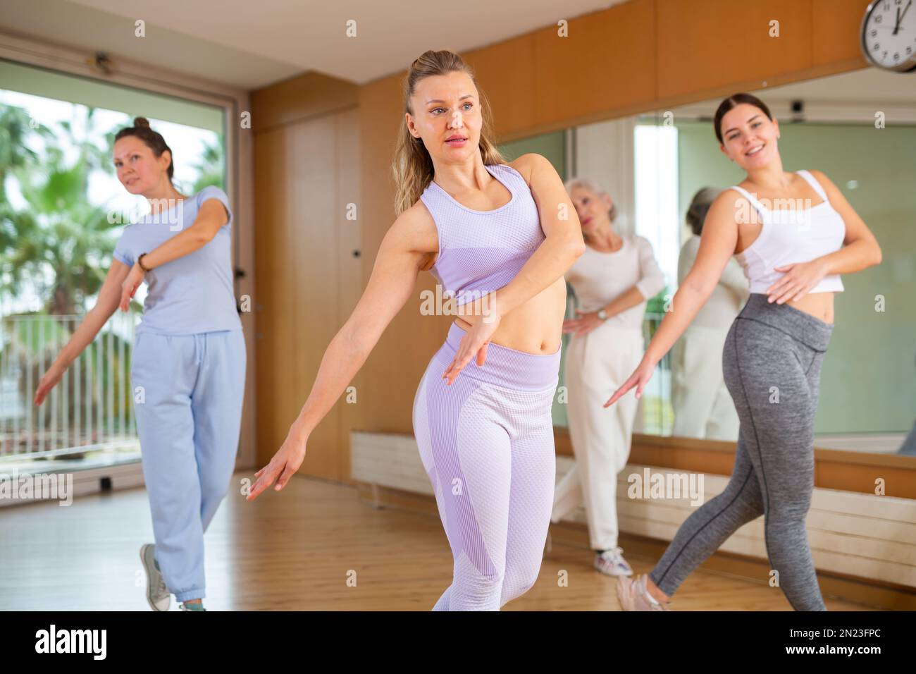 Positive people practicing vigorous lindy hop movements in dance class ...