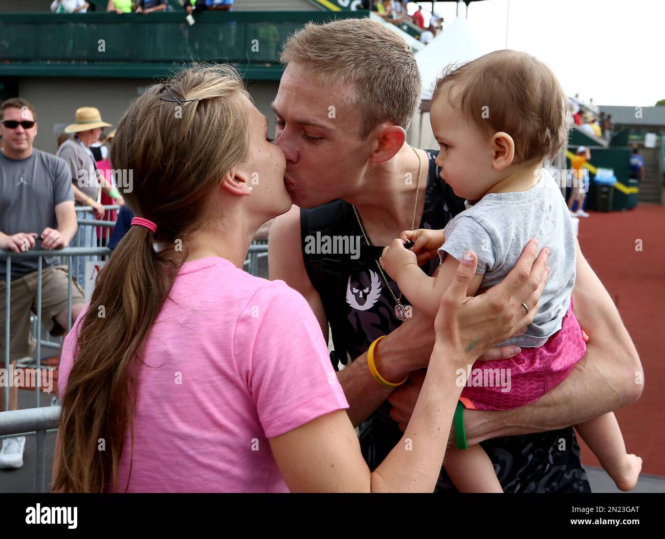 Galen Rupp, center, kisses his wife, Keara Rupp, while holding daughter ...