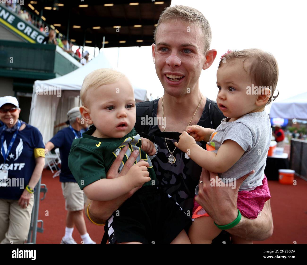 Galen Rupp holds his children, Grayson, left, and Emmie, right, after ...