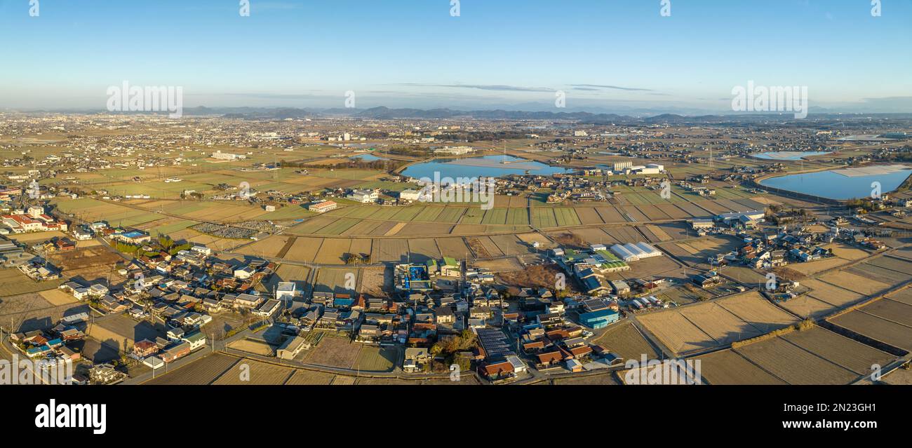 Panoramic aerial view of dry farms by houses and water storage ponds ...