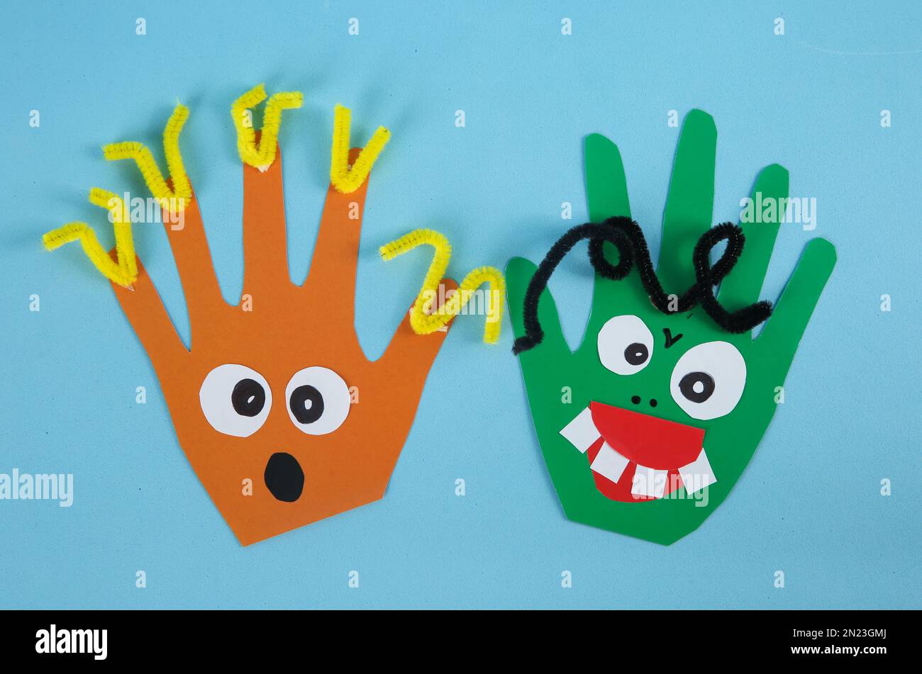 Funny hand shaped monsters on light blue background, flat lay ...