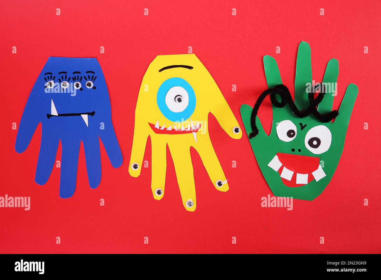 Funny hand shaped monsters on red background, flat lay. Halloween ...