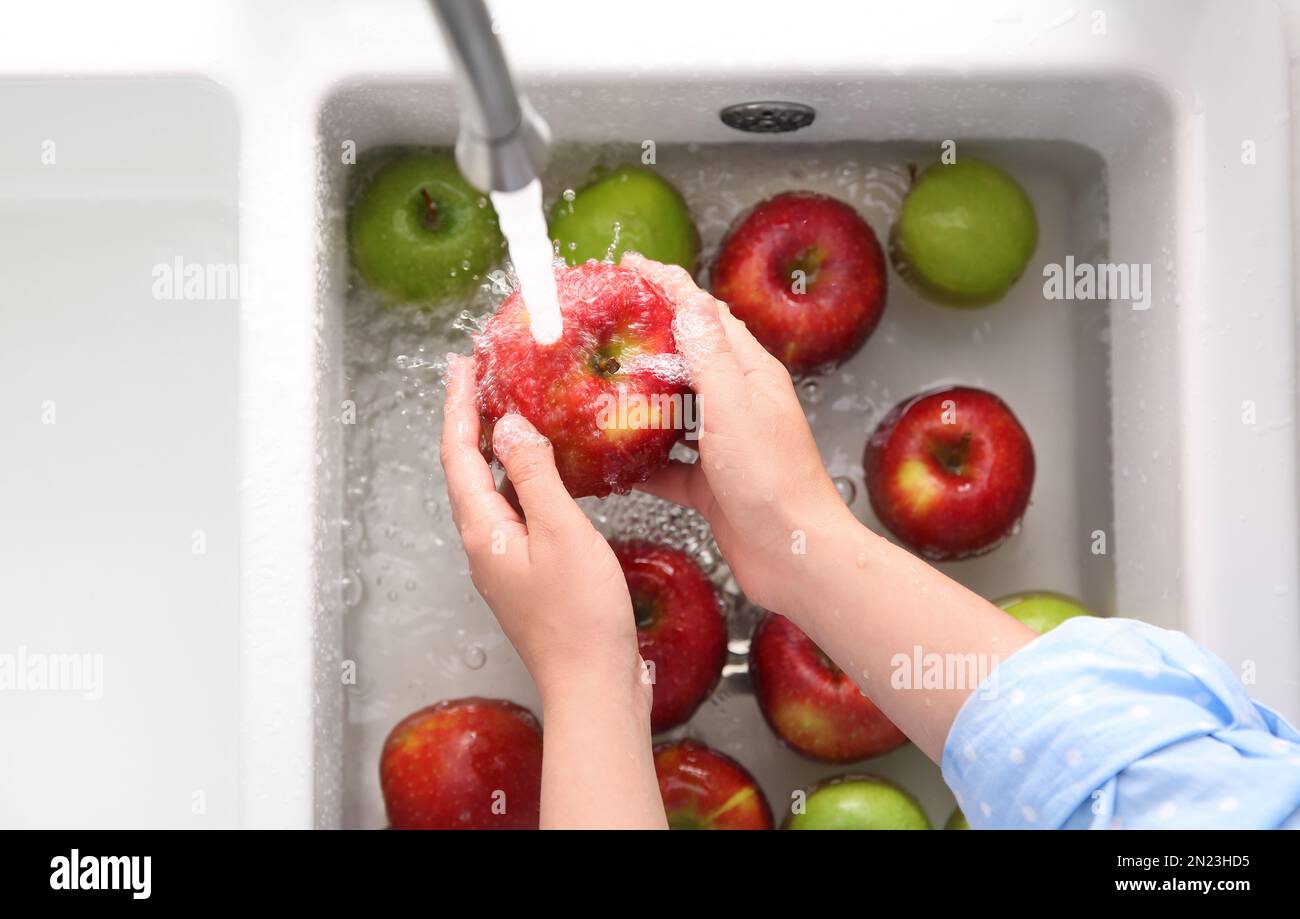 Woman washing fresh apples in kitchen sink, top view Stock Photo - Alamy