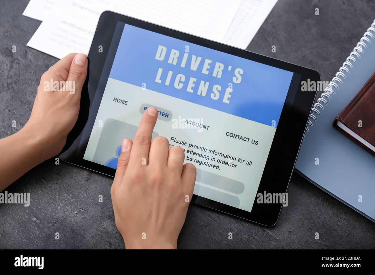 Person using tablet to fill driver's license application form at grey table, closeup Stock Photo ...
