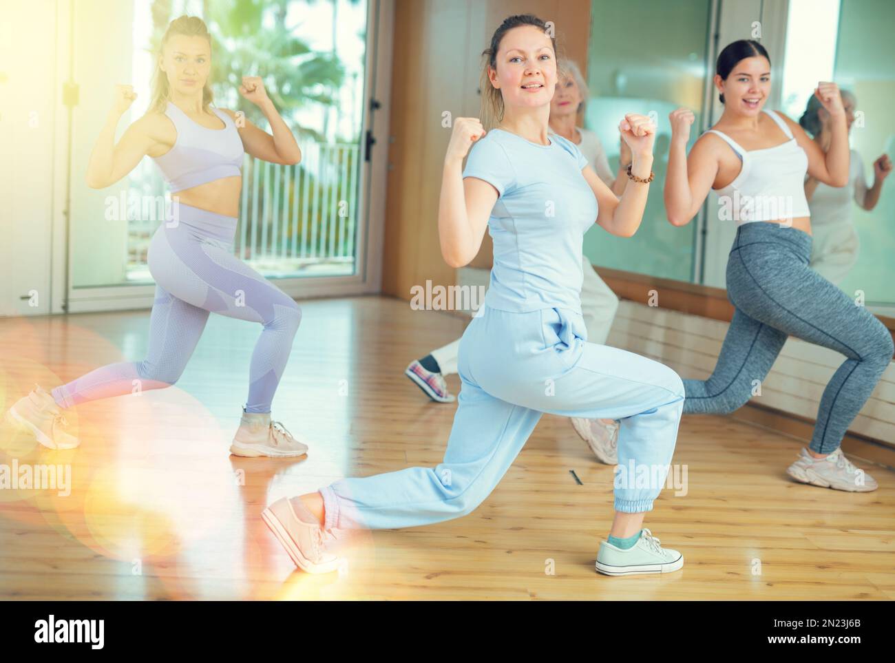Positive people practicing vigorous lindy hop movements in dance class ...