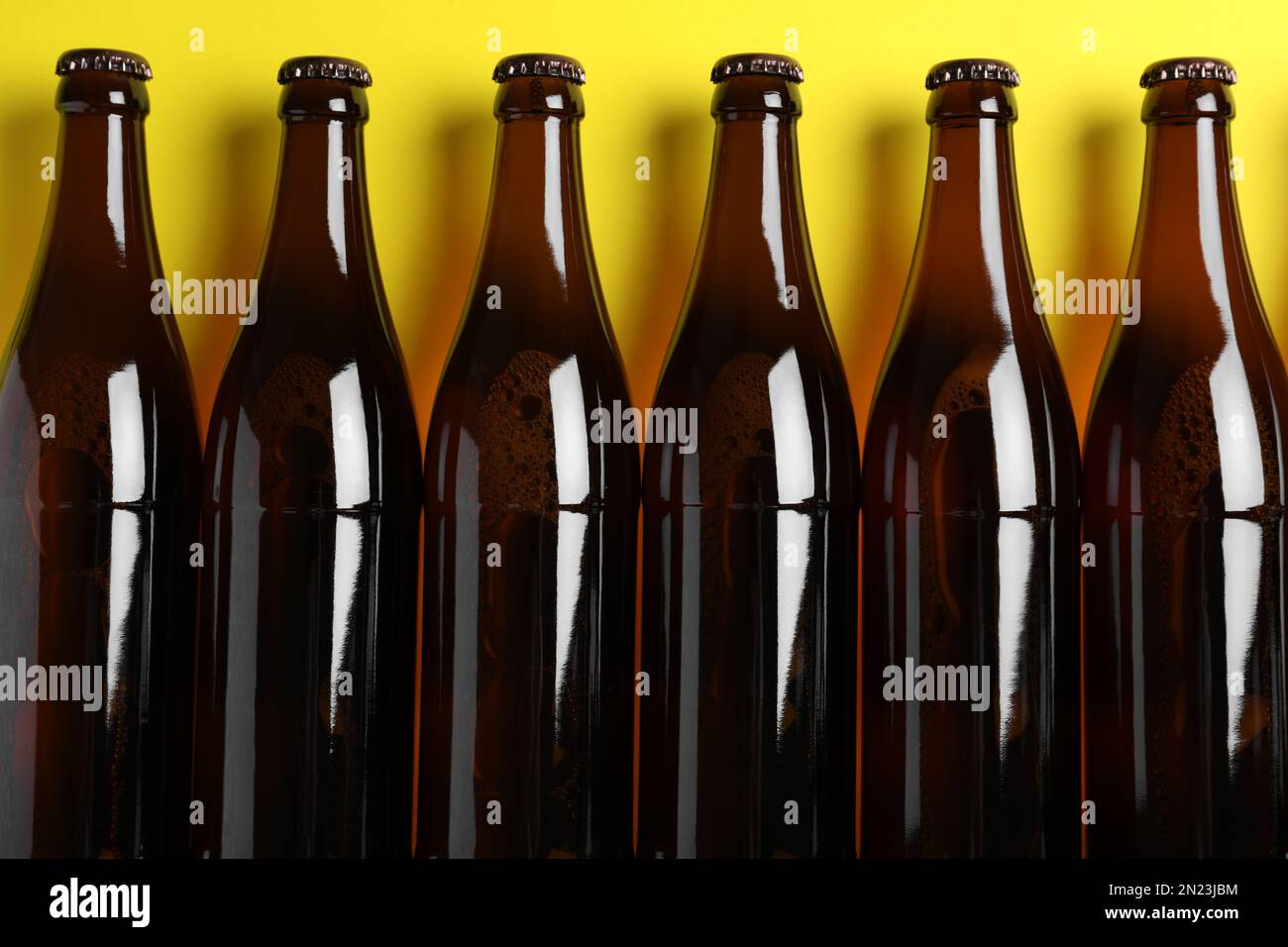 Bottles of beer on yellow background, flat lay Stock Photo - Alamy