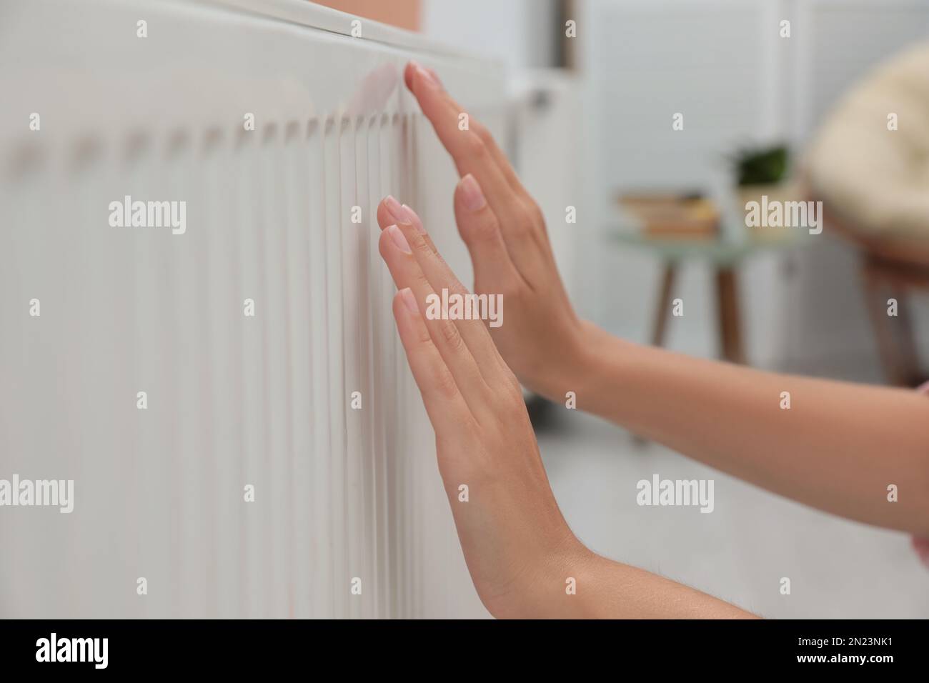 Woman warming hands on heating hi-res stock photography and images - Alamy