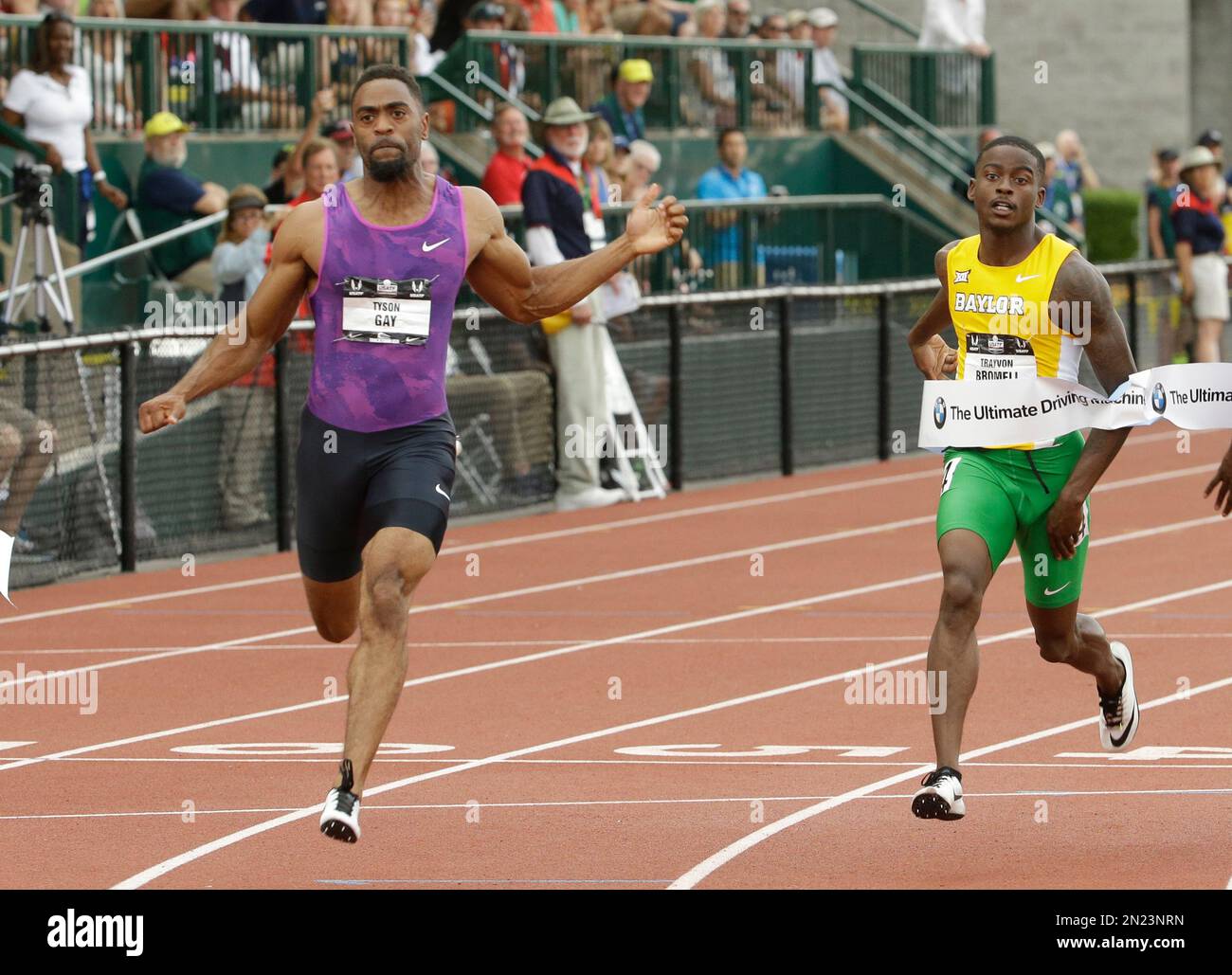 Tyson Gay, left, hits the tape ahead of Trayvon Bromell to win the 100 ...