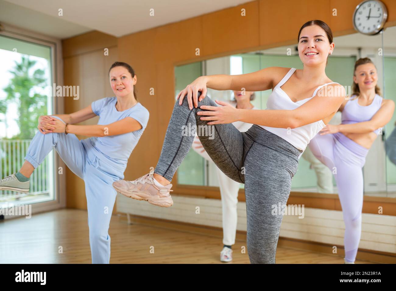 Positive people practicing vigorous lindy hop movements in dance class ...