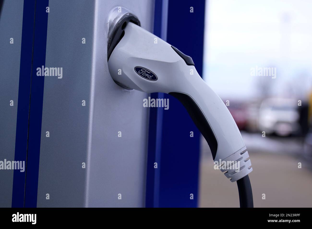 The Ford logo is displayed on charging plug handle an electric vehicle ...