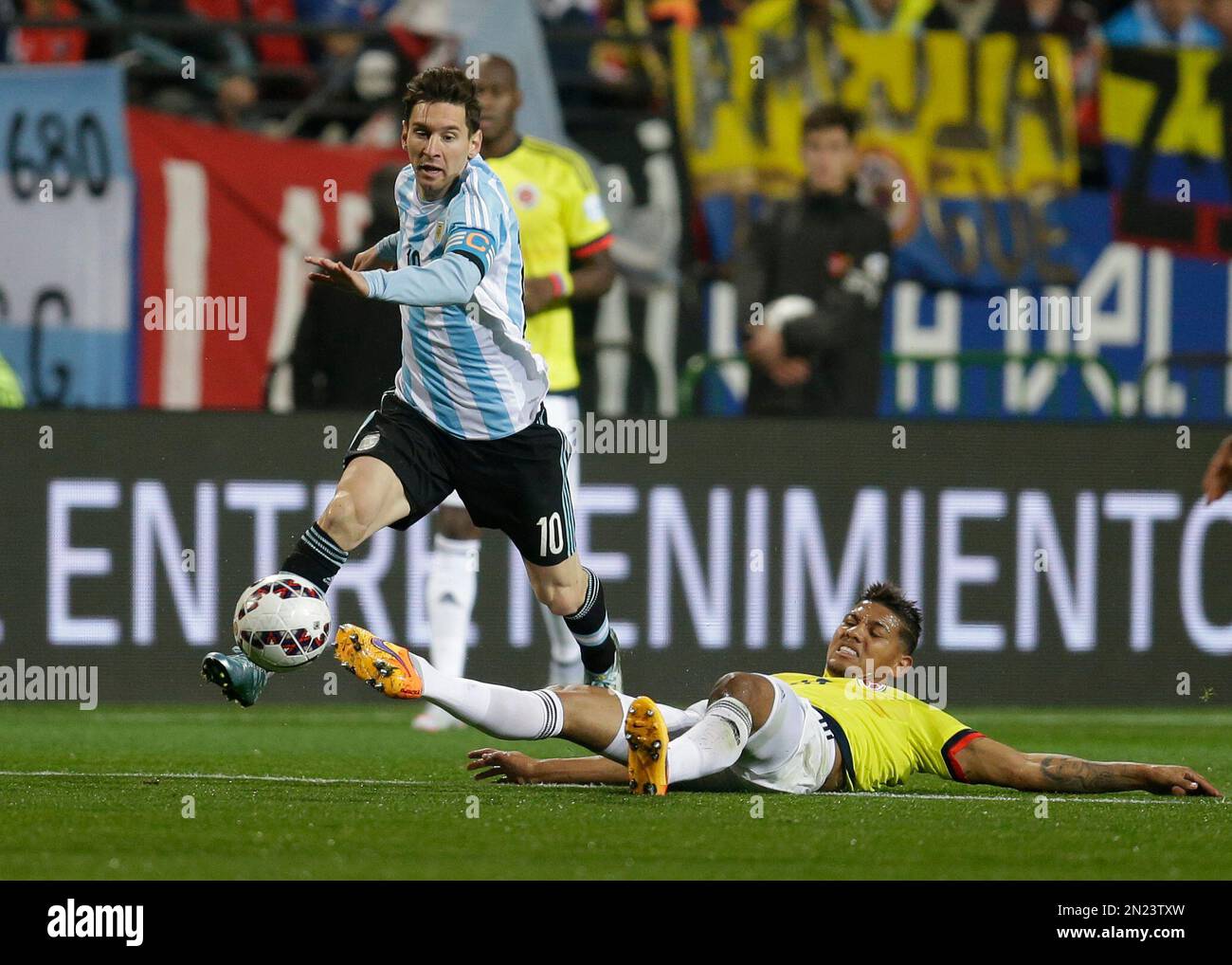 Argentina's Lionel Messi, left, leaps past Colombia's Alexander Mejia ...