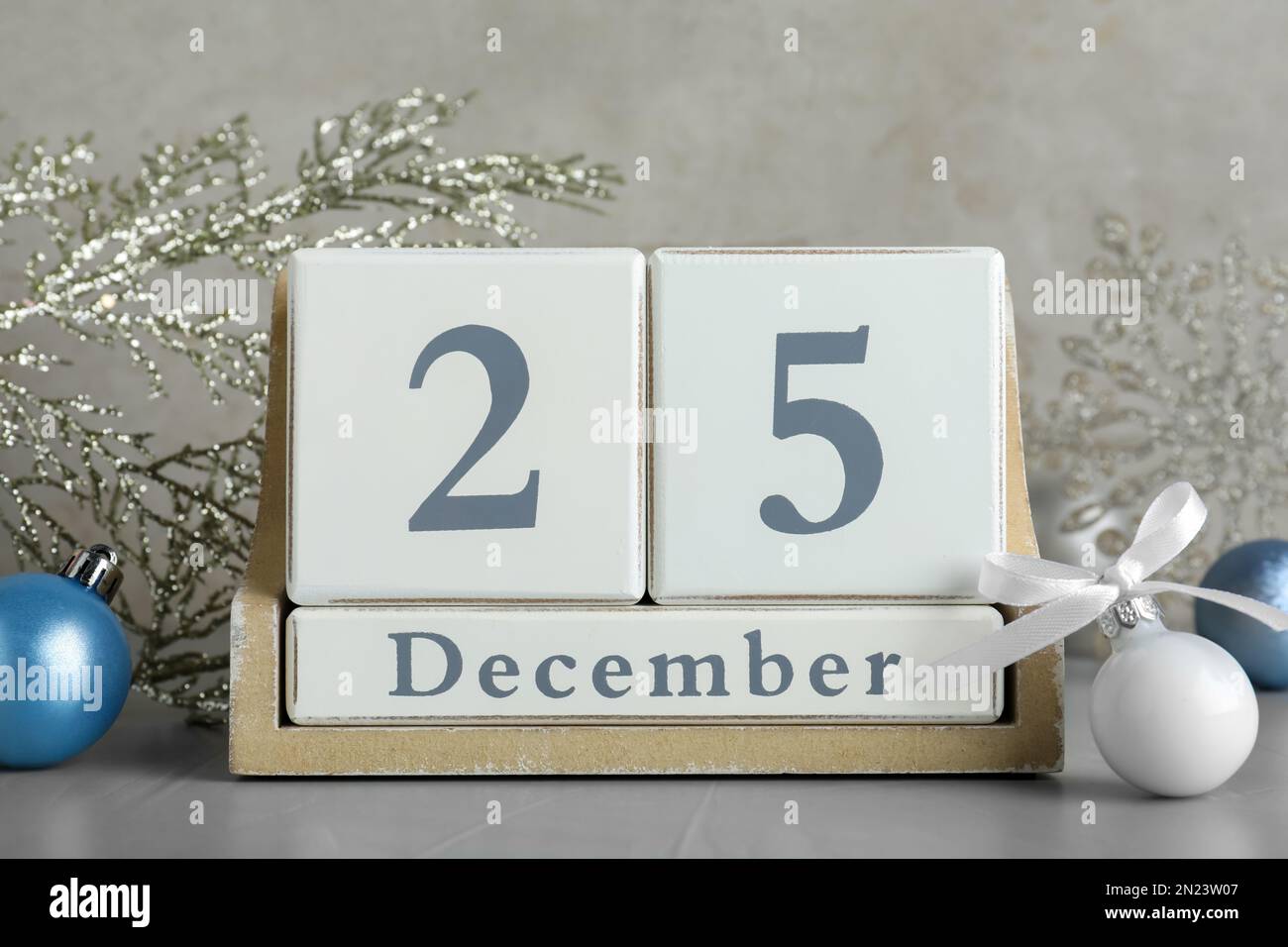 Wooden block calendar and Christmas decor on light grey stone table ...