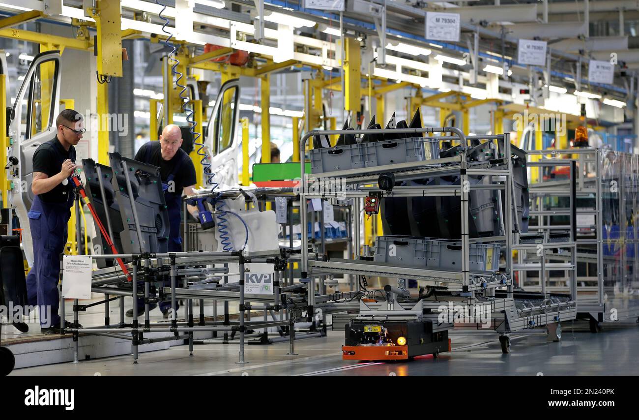 Two worker take parts from an autonomous car part distribution system ...