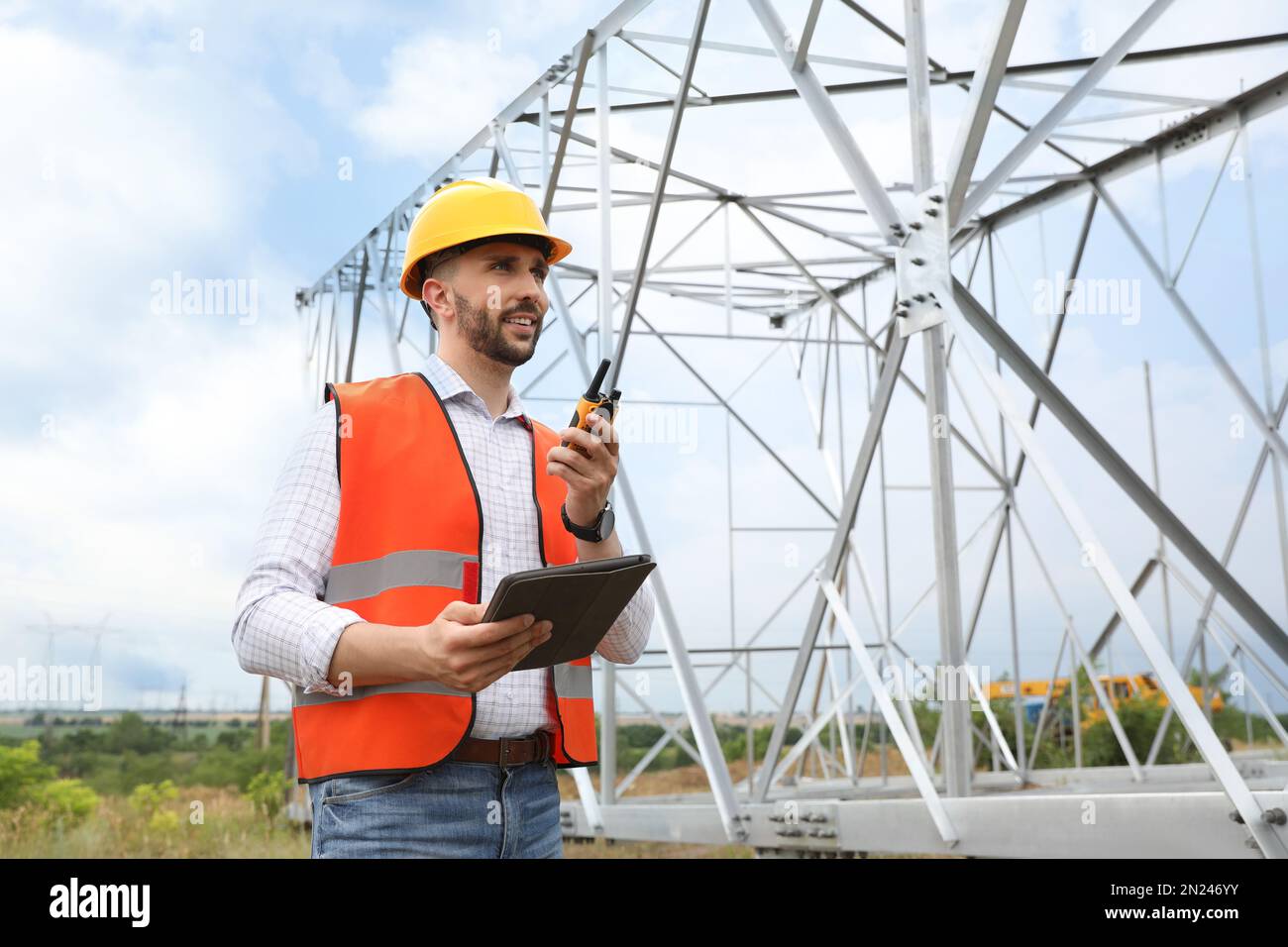 Professional engineer with tablet and walkie talkie near high voltage ...