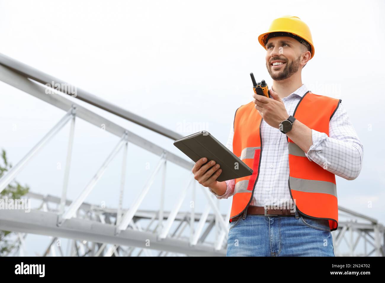 Professional engineer with tablet and walkie talkie near high voltage ...