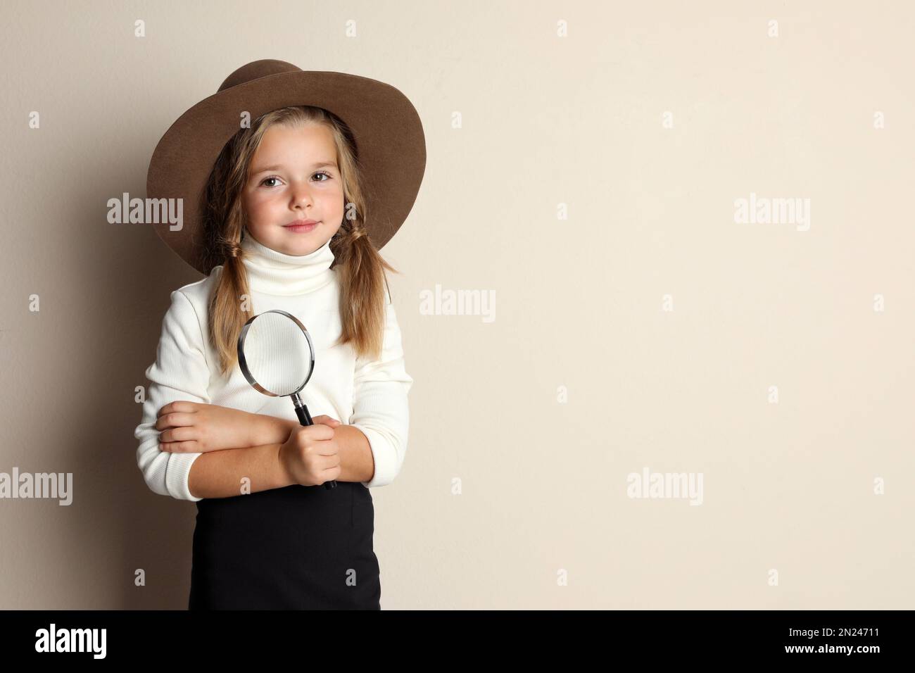 Cute little child in hat with magnifying glass playing detective on ...