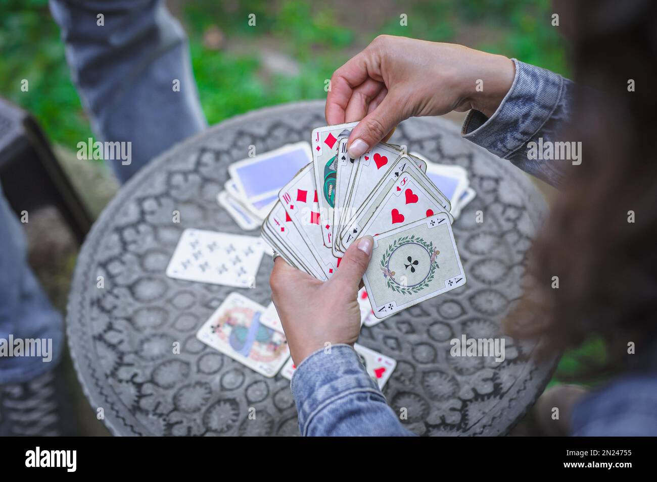 Card playing in a spring garden: Couple are sitting on a table ...
