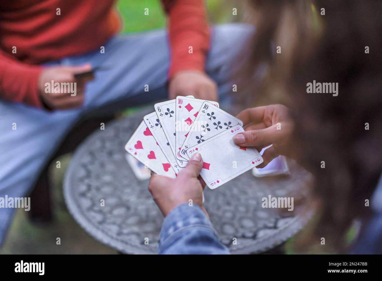Card playing in a spring garden: Couple are sitting on a table ...