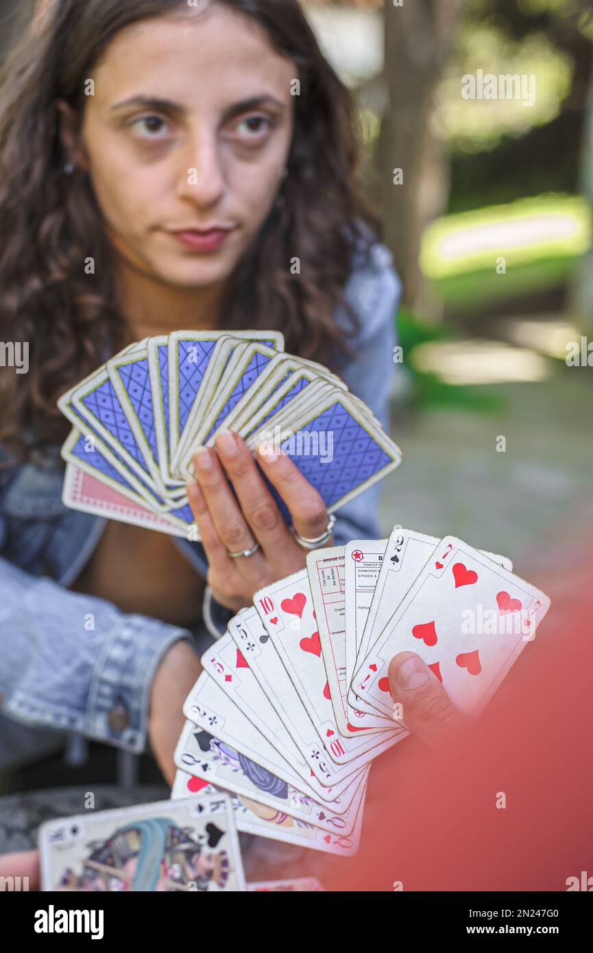 Card playing in a spring garden: Couple are sitting on a table ...