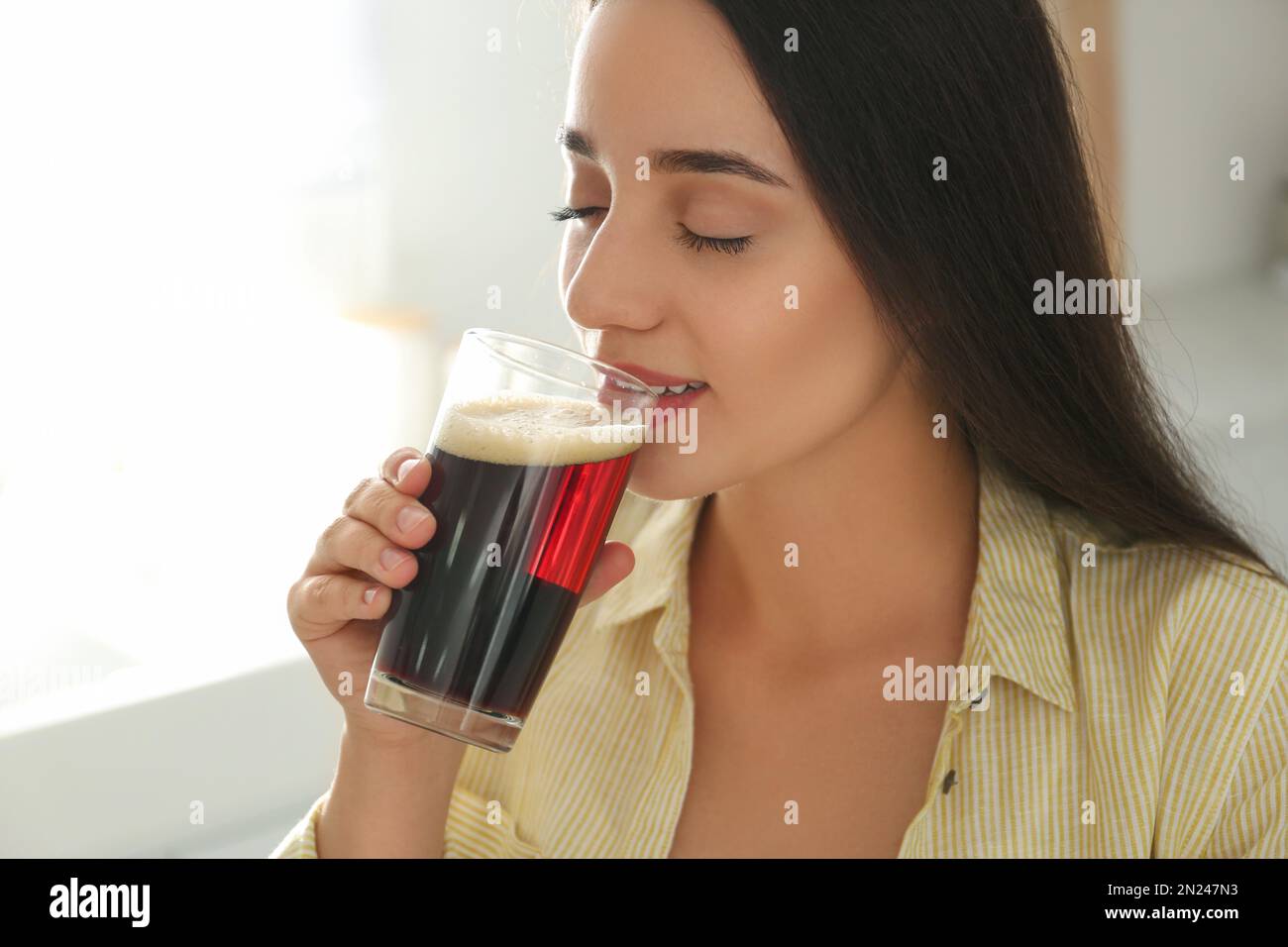 Beautiful woman with cold kvass indoors. Traditional Russian summer ...