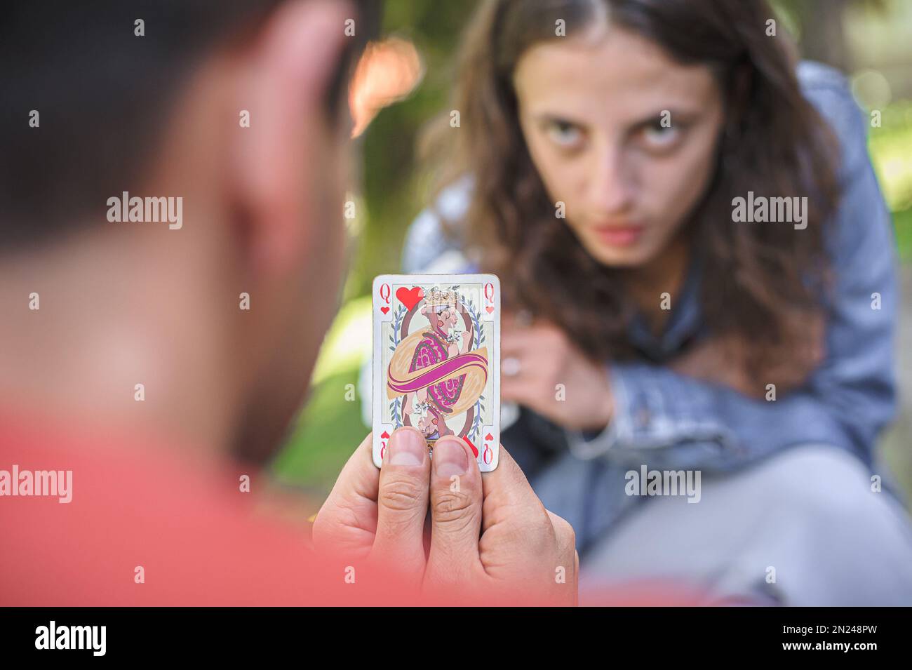 Card playing in a spring garden: Couple are sitting on a table ...