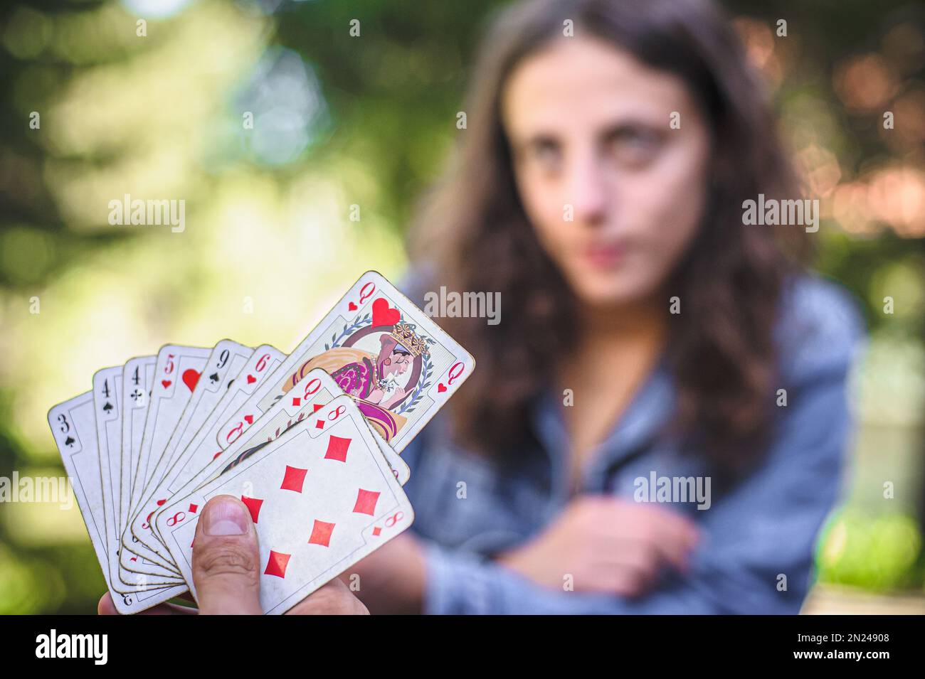 Card playing in a spring garden: Couple are sitting on a table ...