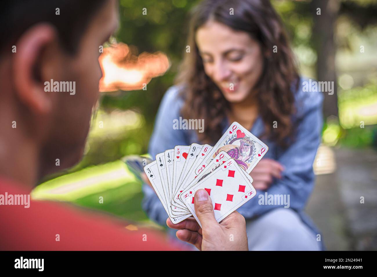 Card playing in a spring garden: Couple are sitting on a table ...