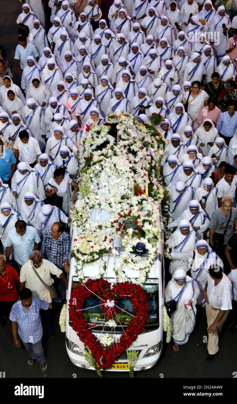 Nuns and others walk beside the garlanded coffin of Sister Nirmala ...