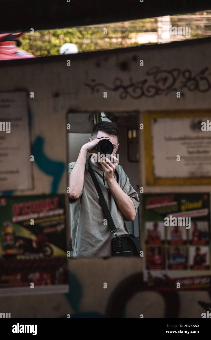 A selective focus of the photographer's reflection in the mirror, with ...