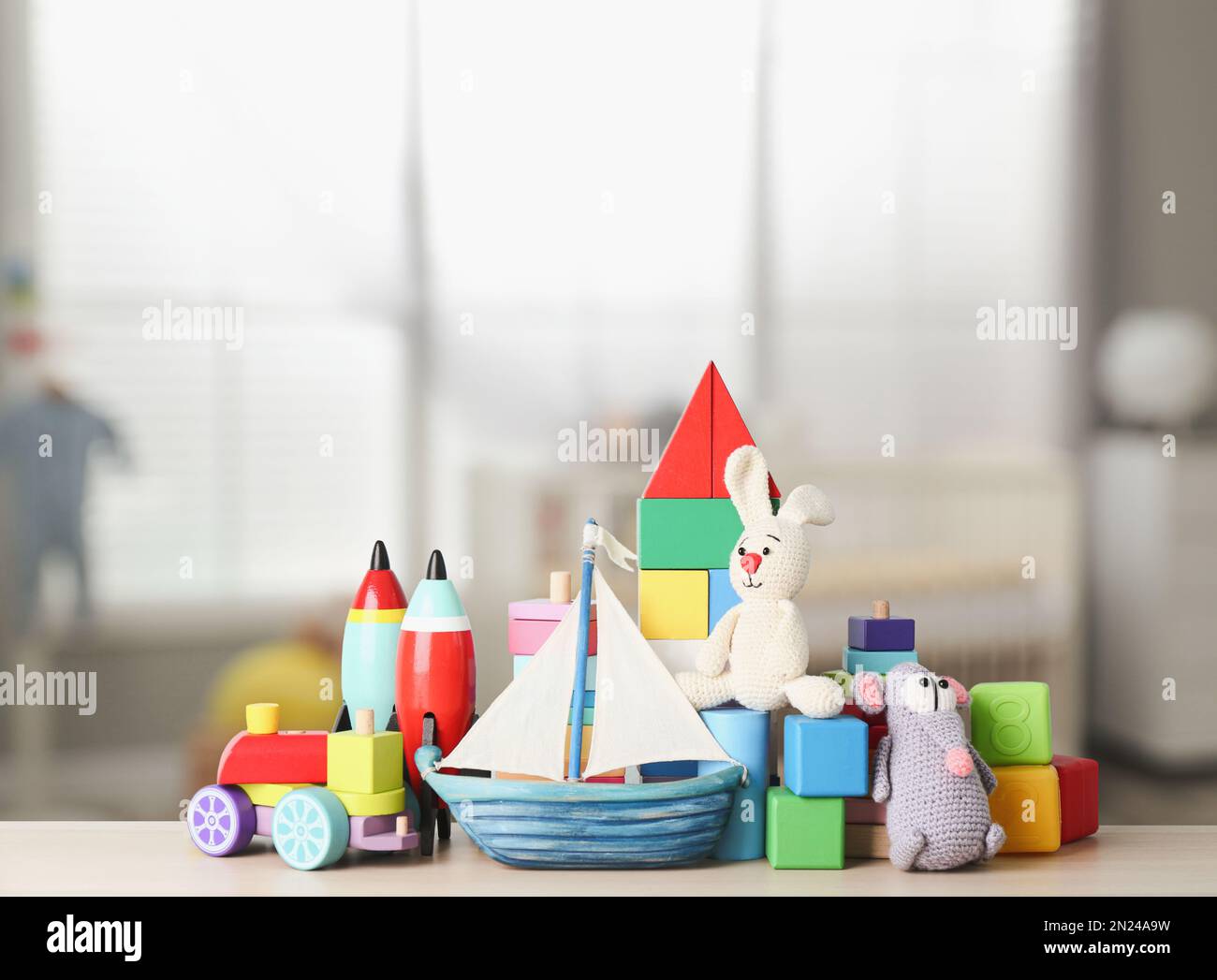Set of different cute toys on wooden table in children's room Stock ...