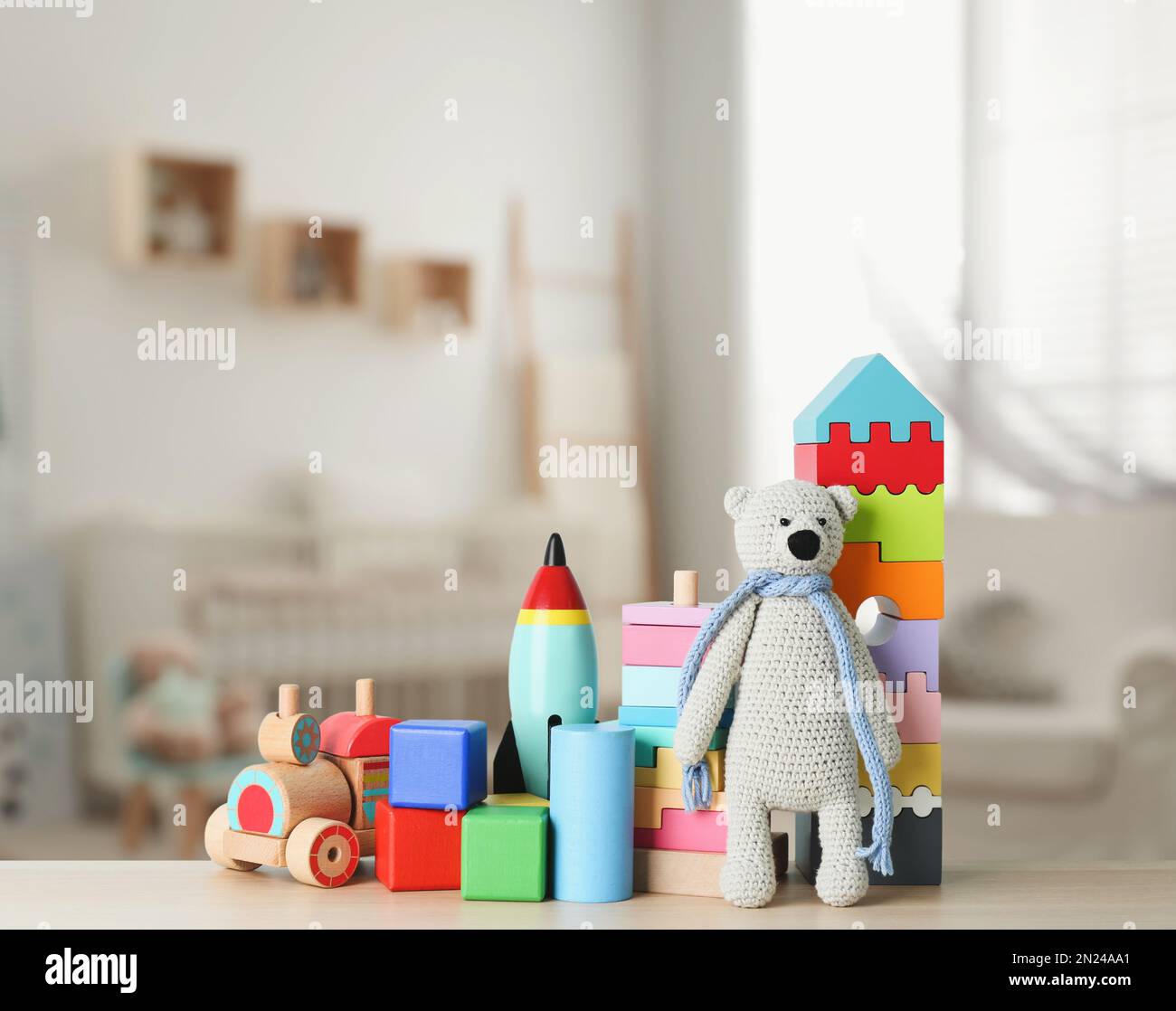 Set of different cute toys on wooden table in children's room Stock ...