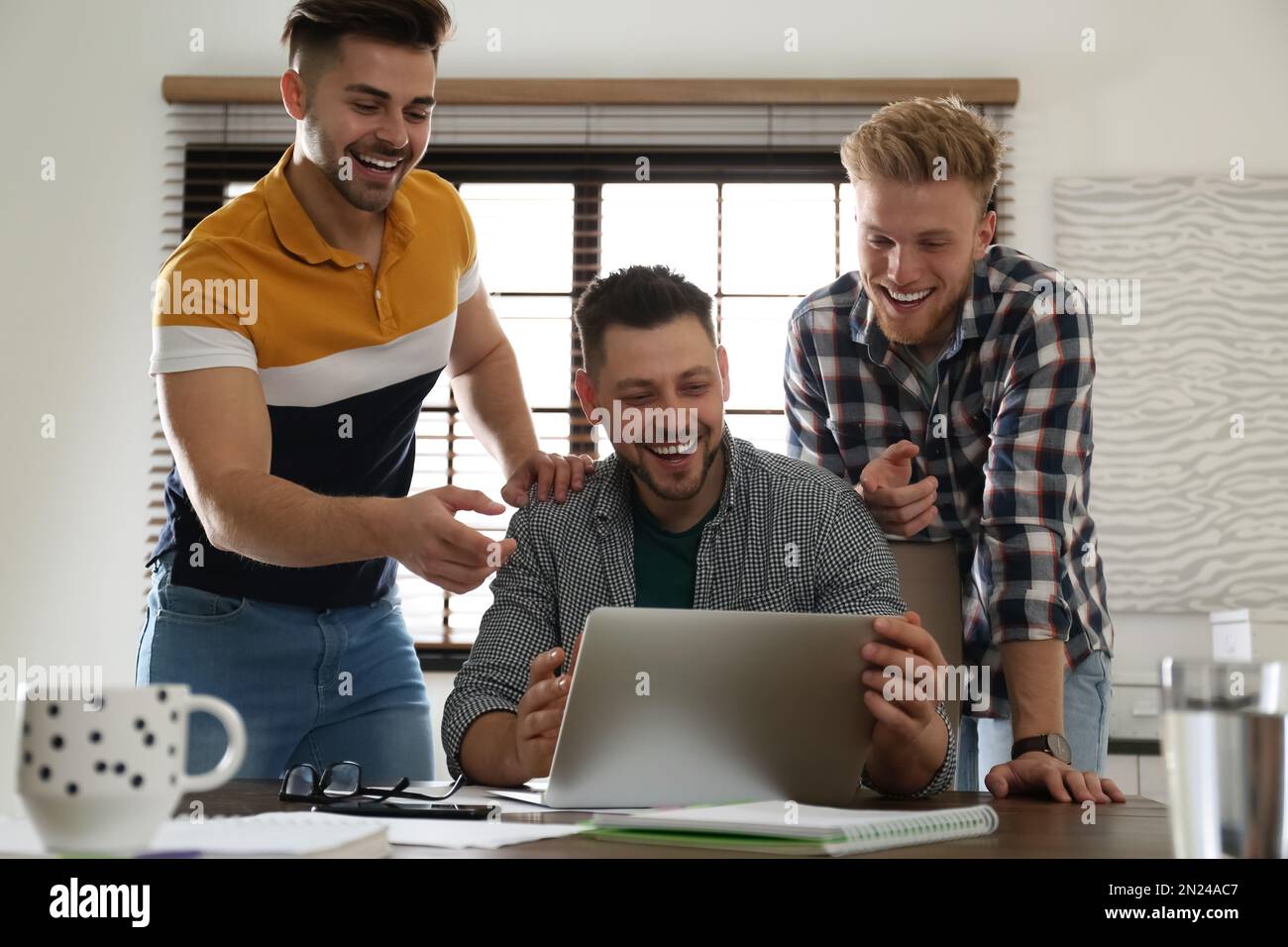 Happy friends working together in modern office Stock Photo - Alamy
