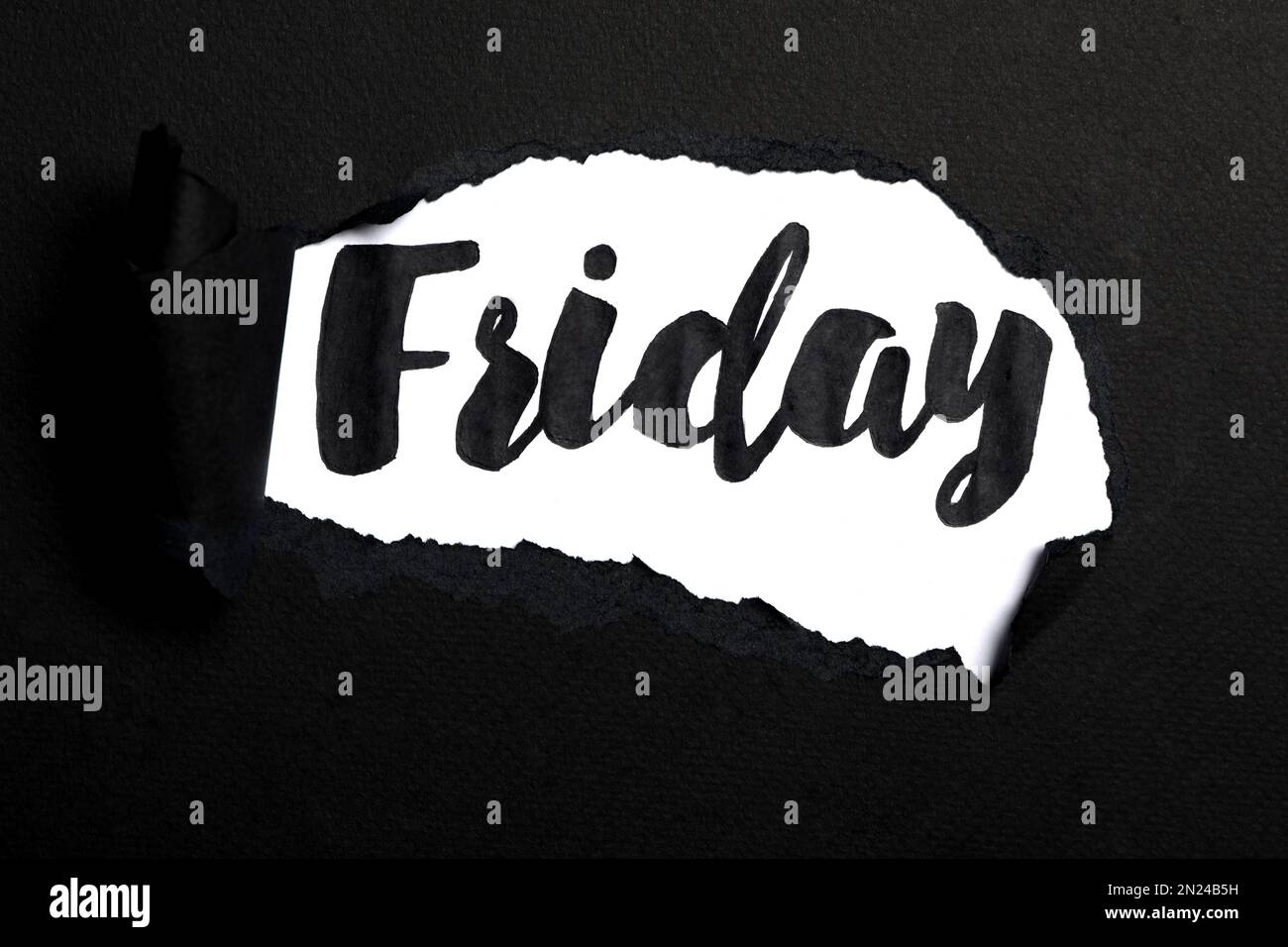 Word Friday, view through hole in black torn paper Stock Photo - Alamy