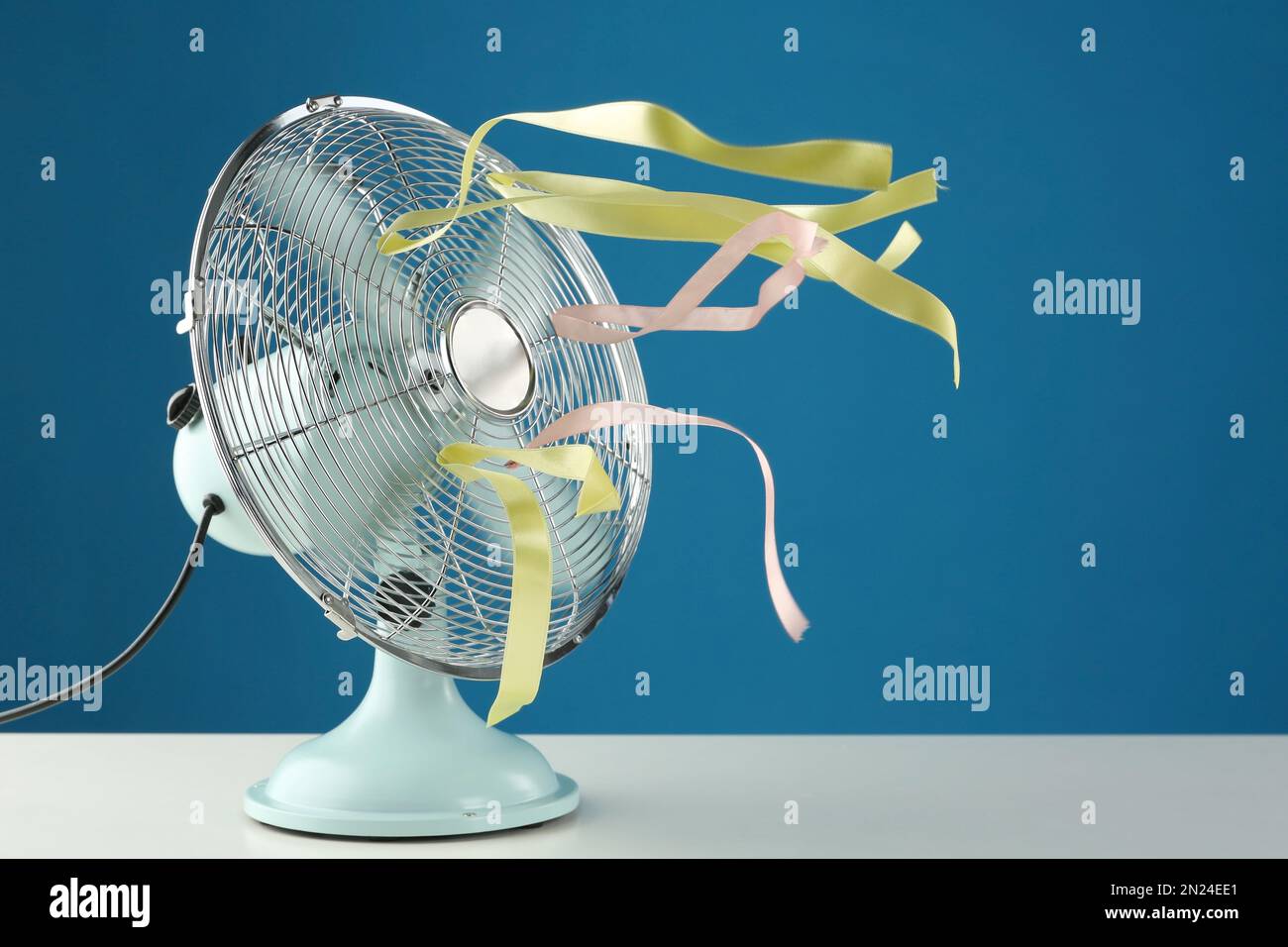 Electric fan on white table against blue background. Summer heat Stock ...