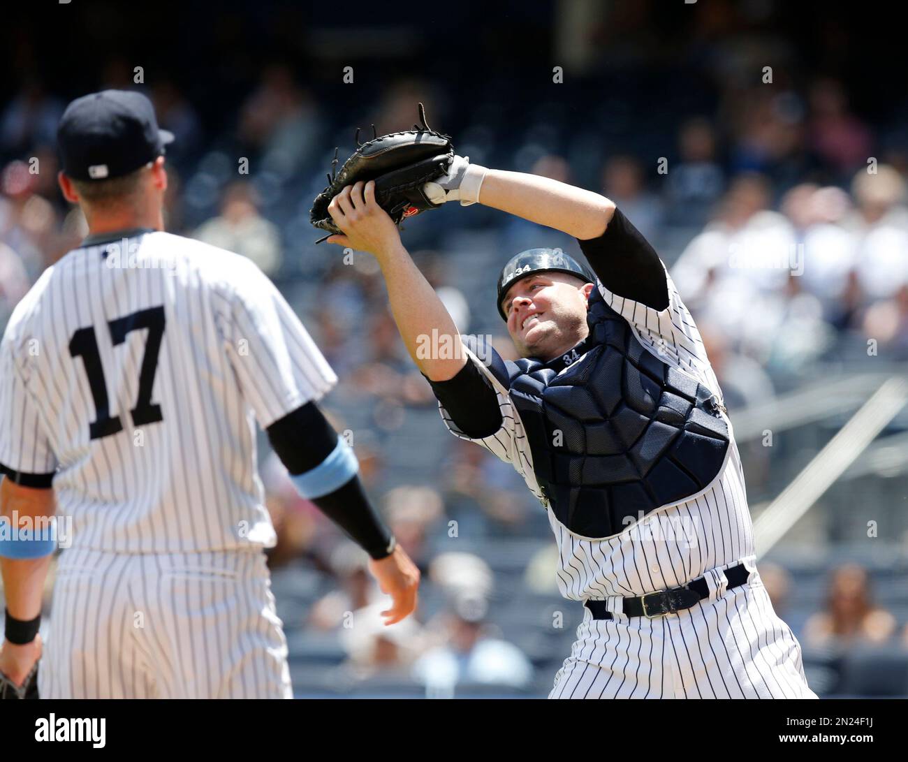 Shortstop Brendan Ryan (17) watches as New York Yankees catcher Brian McCann (34) reaches an ...